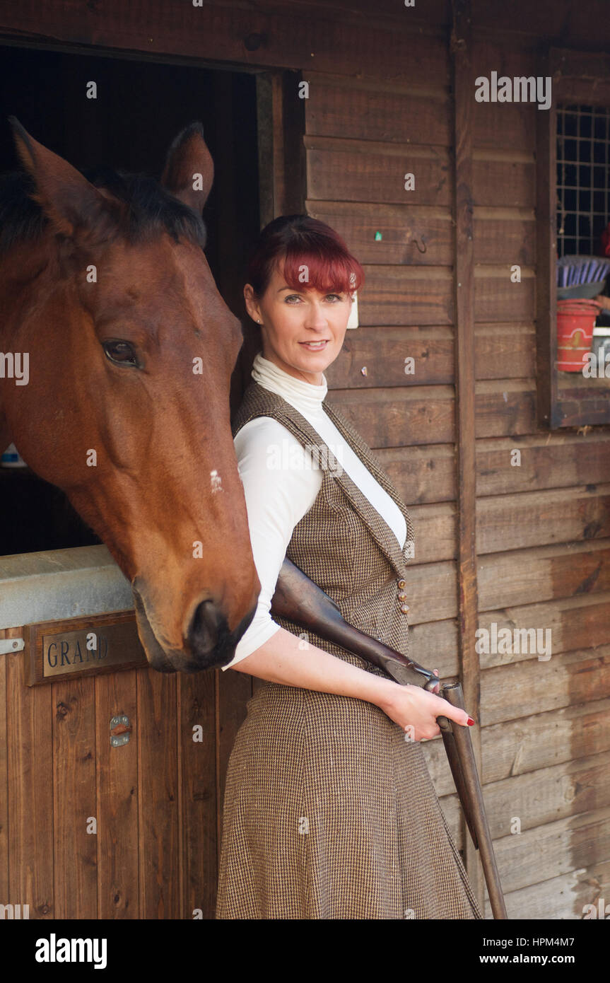 Beautiful woman in gamekeepers tweed suit at a stable with a vintage ...