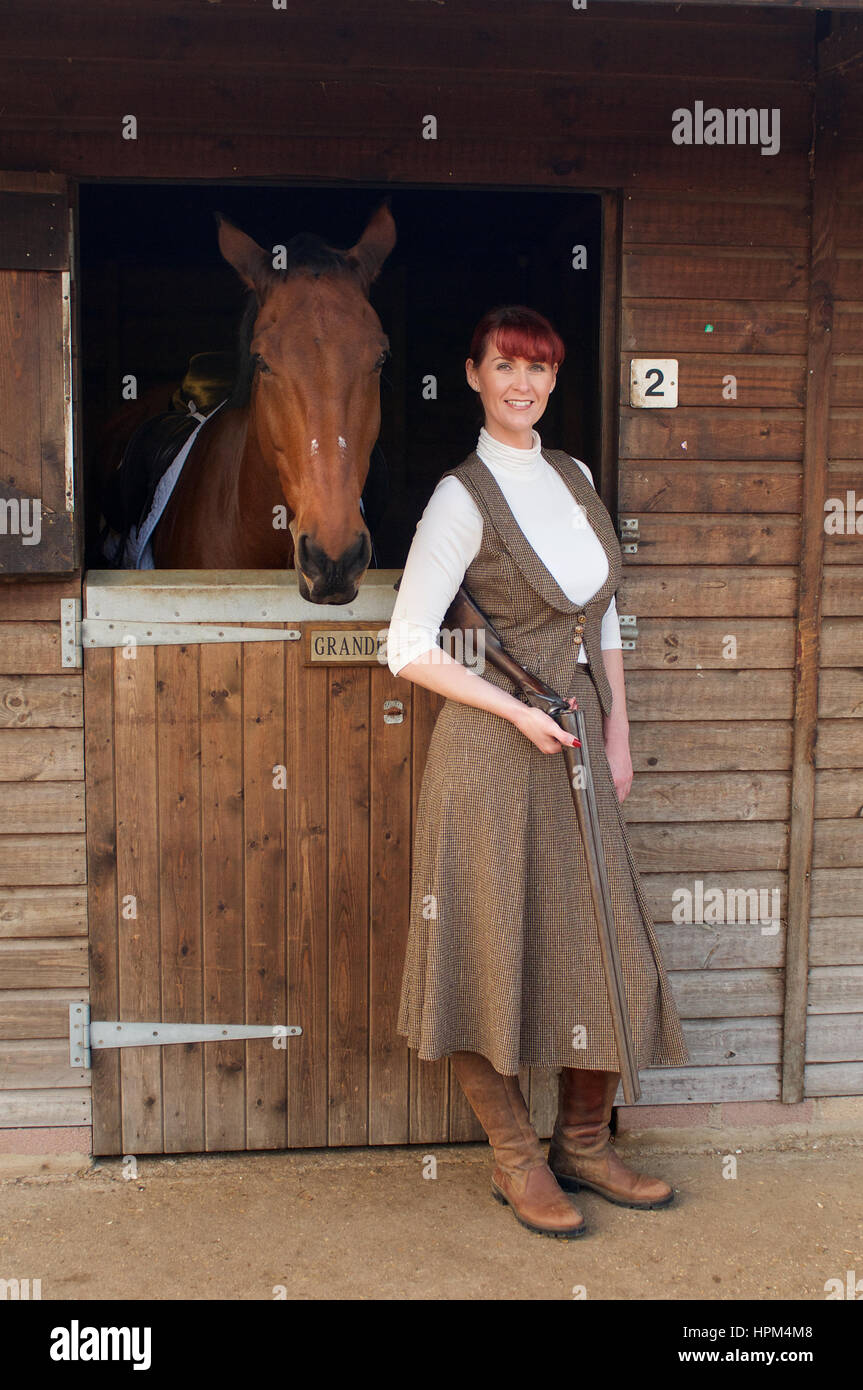 Beautiful woman in gamekeepers tweed suit at a stable with a vintage ...