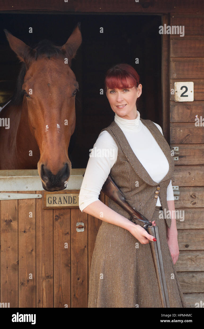 Beautiful woman in gamekeepers tweed suit at a stable with a vintage ...