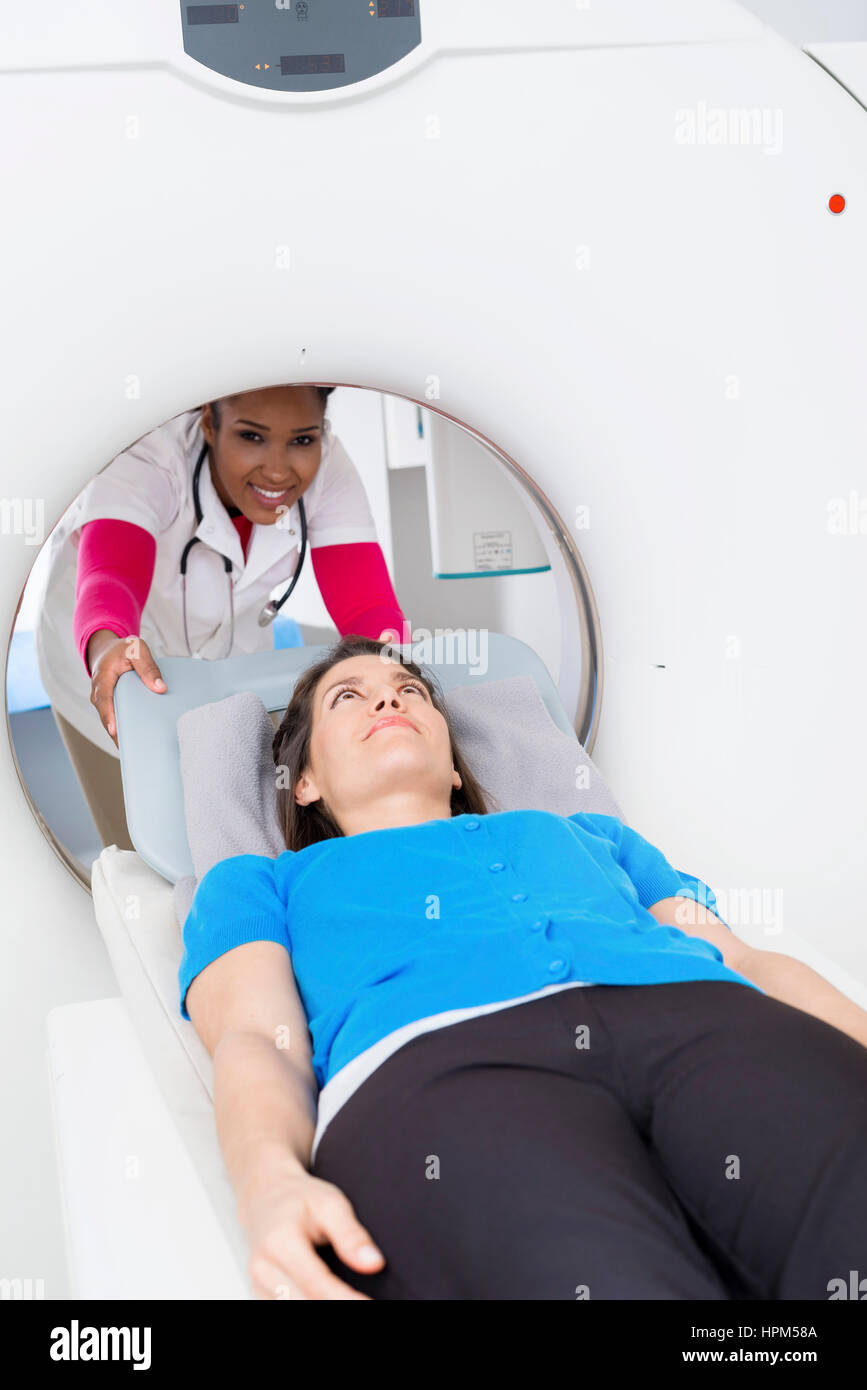 Portrait of confident doctor preparing female patient for CT scan in ...