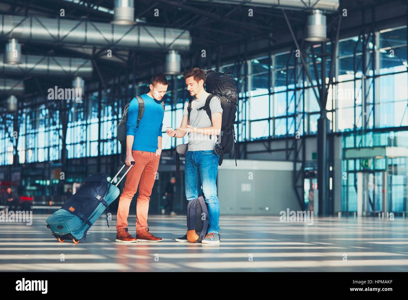 Two friends traveling together. Travelers waiting at the airport ...