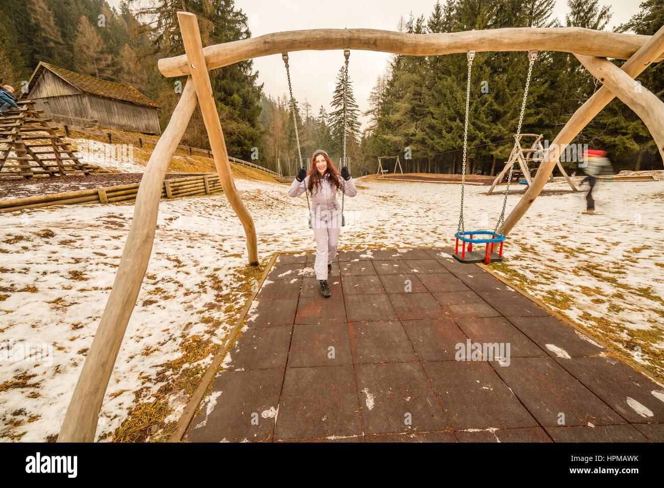Happy woman rocking on the swing in a snowy park in mountains Stock ...