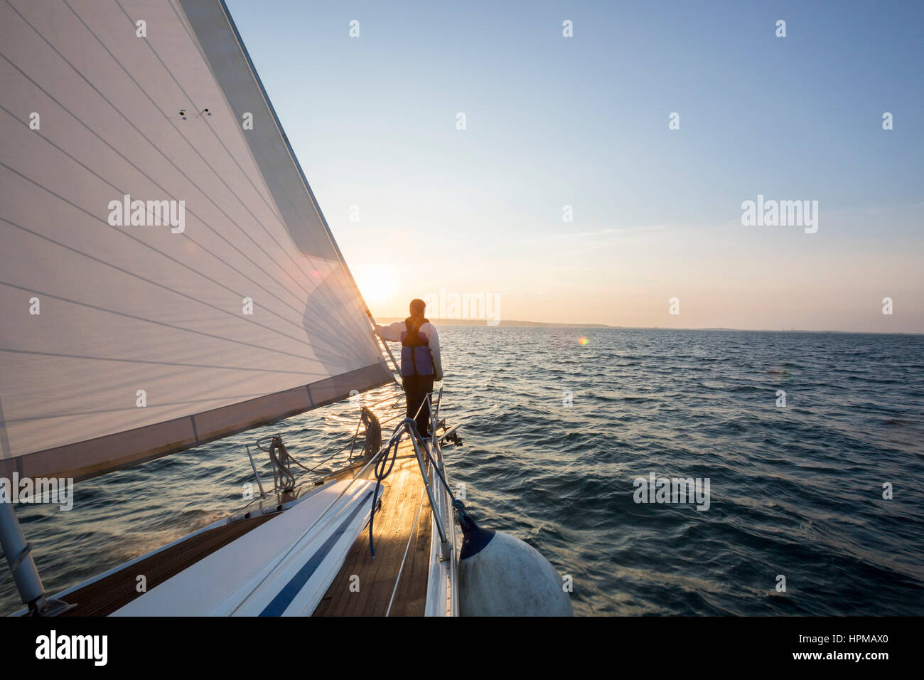 Rear view of man looking at beautiful sea from bow of sail boat during ...