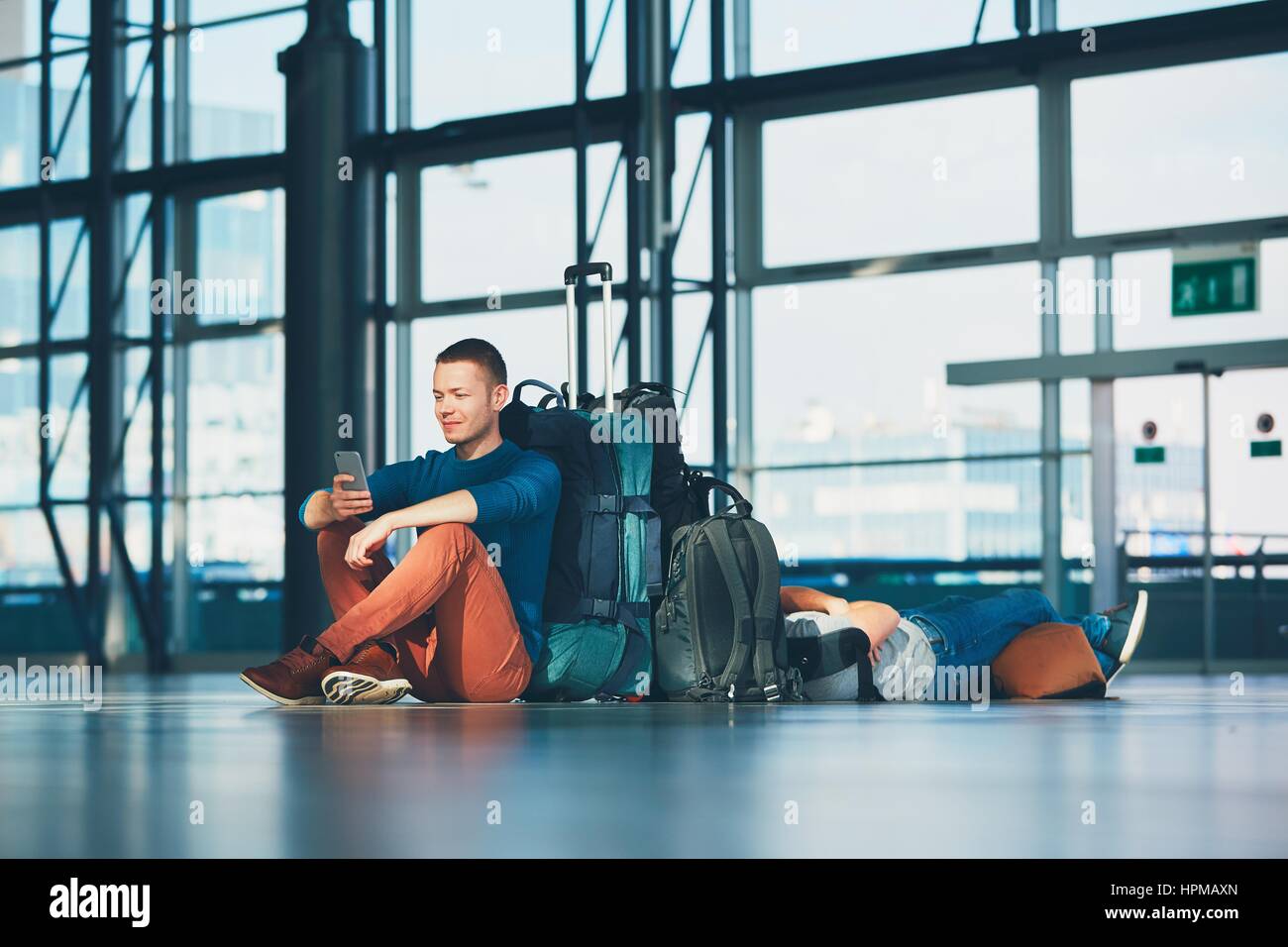 Two friends traveling together. Travelers waiting at the airport ...