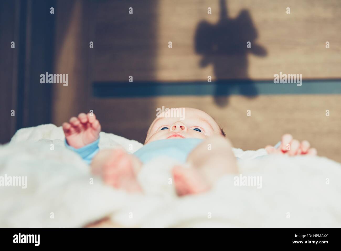 Little boy lying in bed under shadow of the toy Stock Photo - Alamy