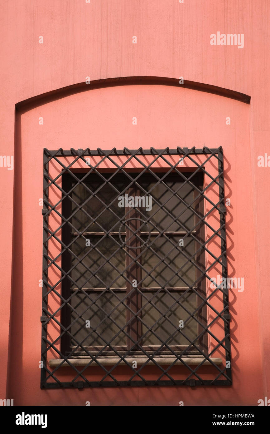 Window with cast iron grill on facade of old architectural building in ...