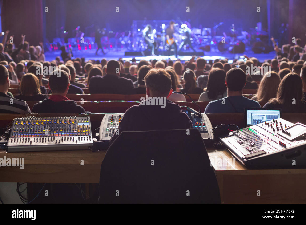 Soundman working on the mixing console in concert hall Stock Photo - Alamy