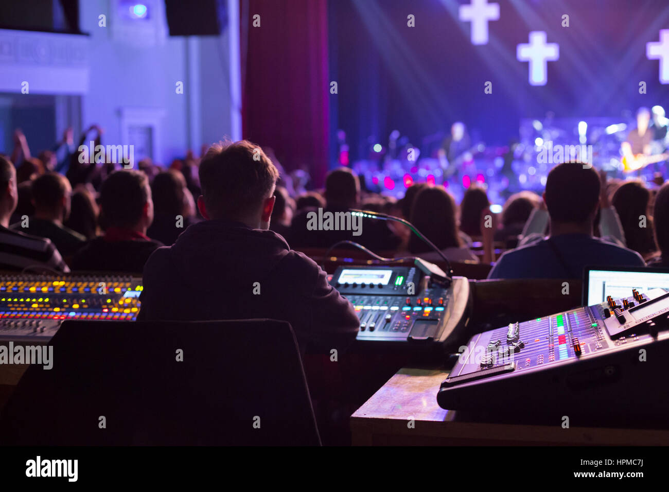 Soundman working on the mixing console in concert hall Stock Photo - Alamy