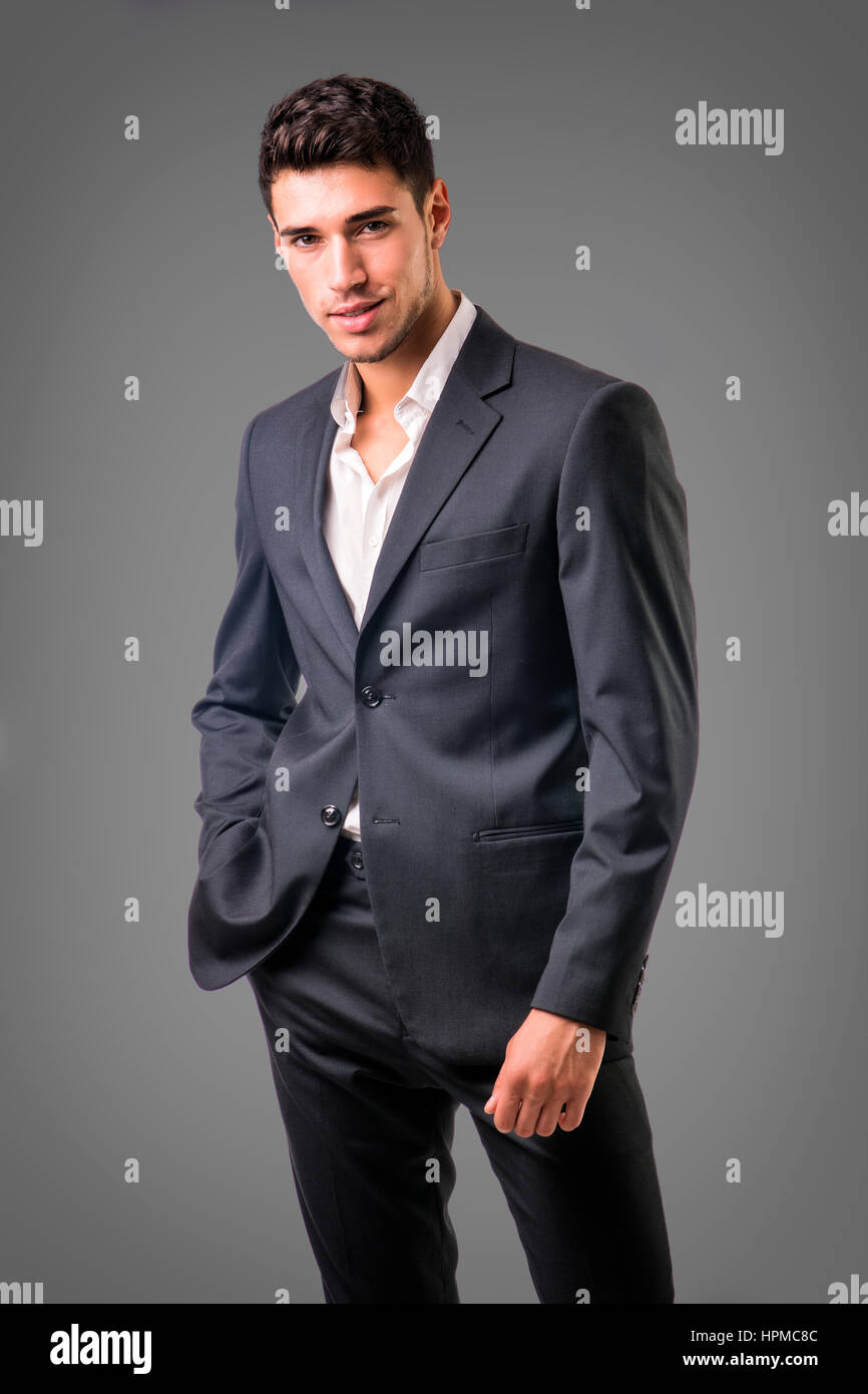 Young businessman confidently posing in front of camera, wearing ...