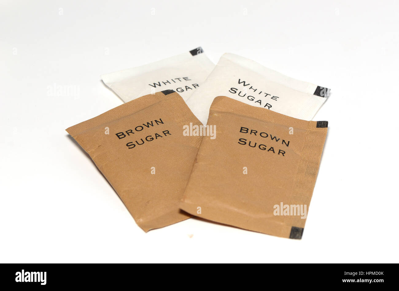 Small paper package of white and brown sugars on isolated white ...