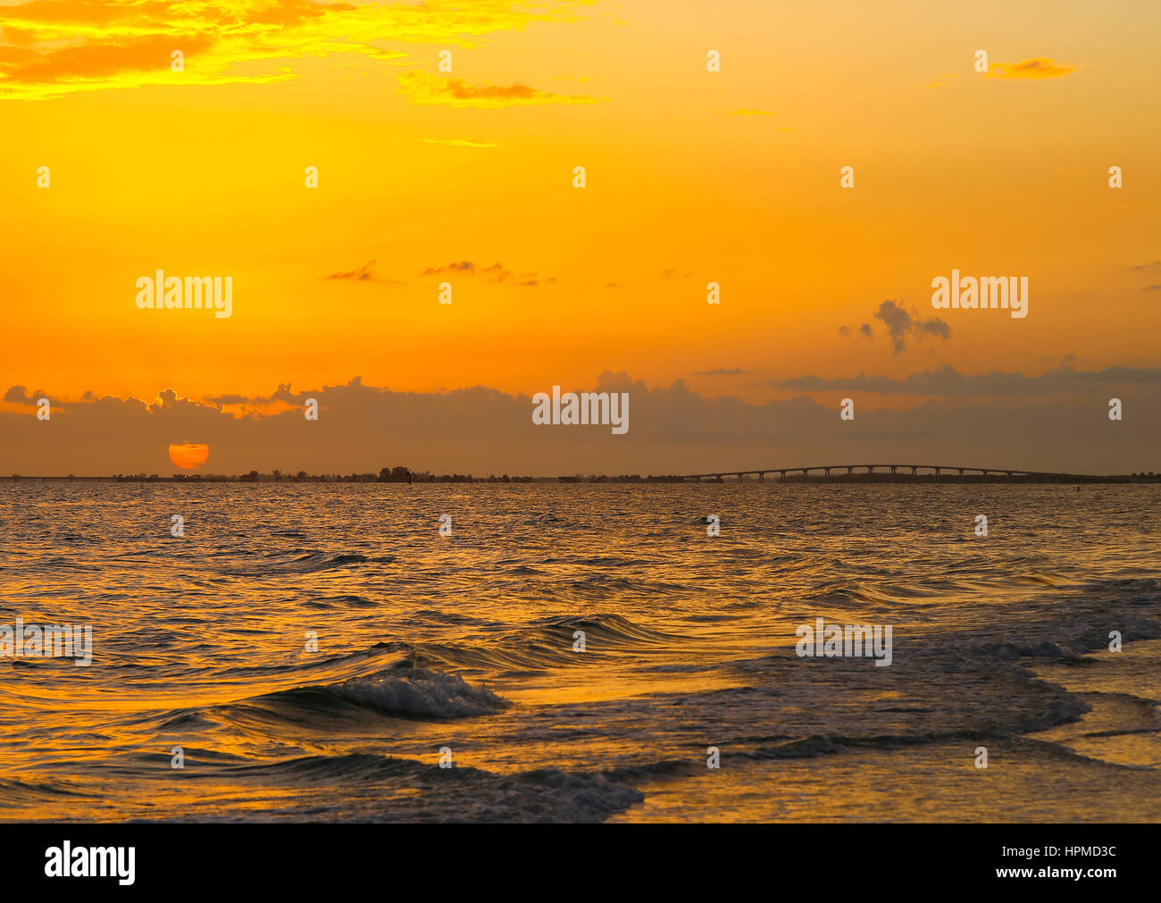 The sun sinking into the Gulf of Mexico in Fort Myers Beach with gentle ...
