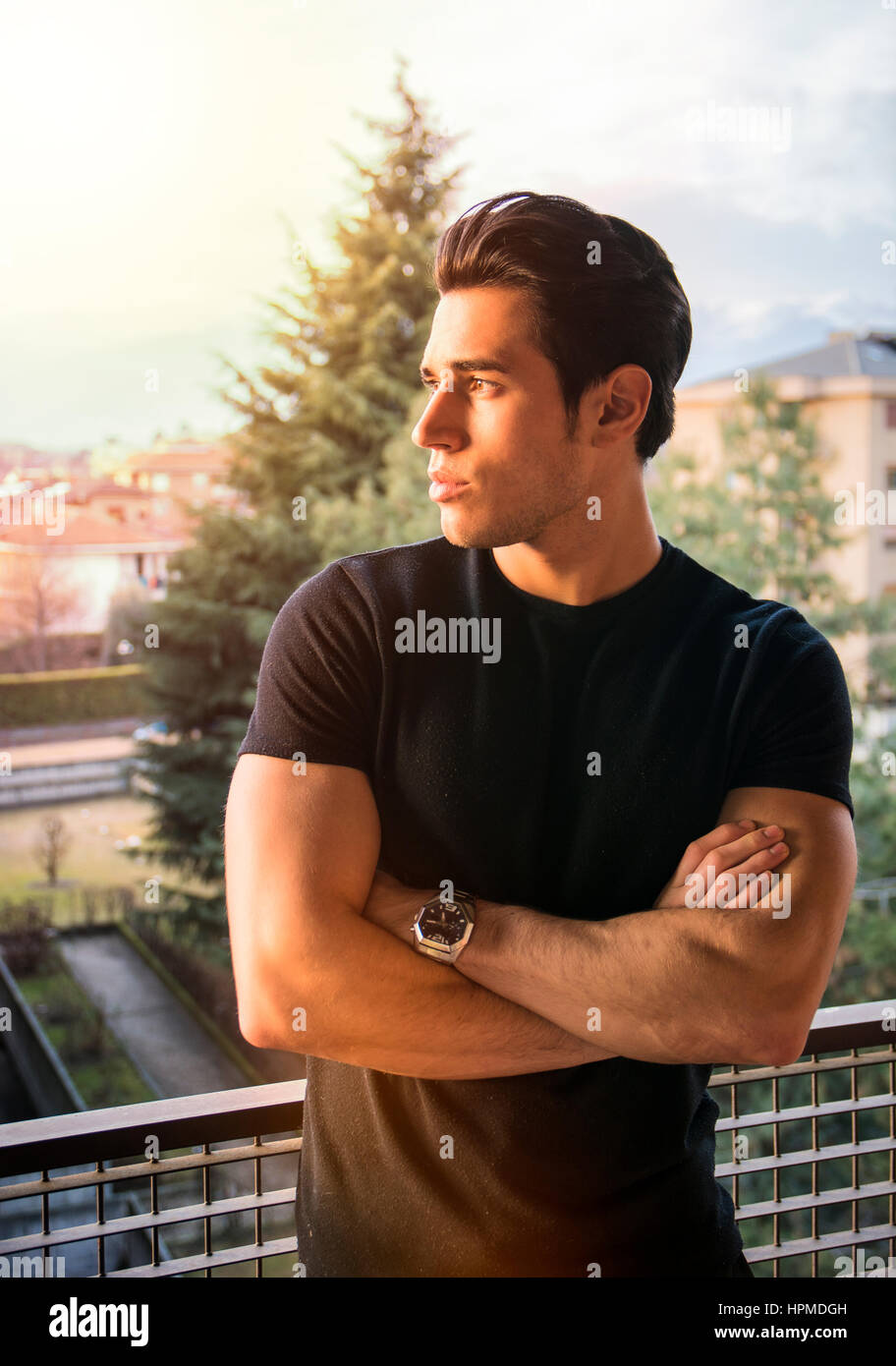 Side profile of a man standing with arms crossed hi-res stock ...