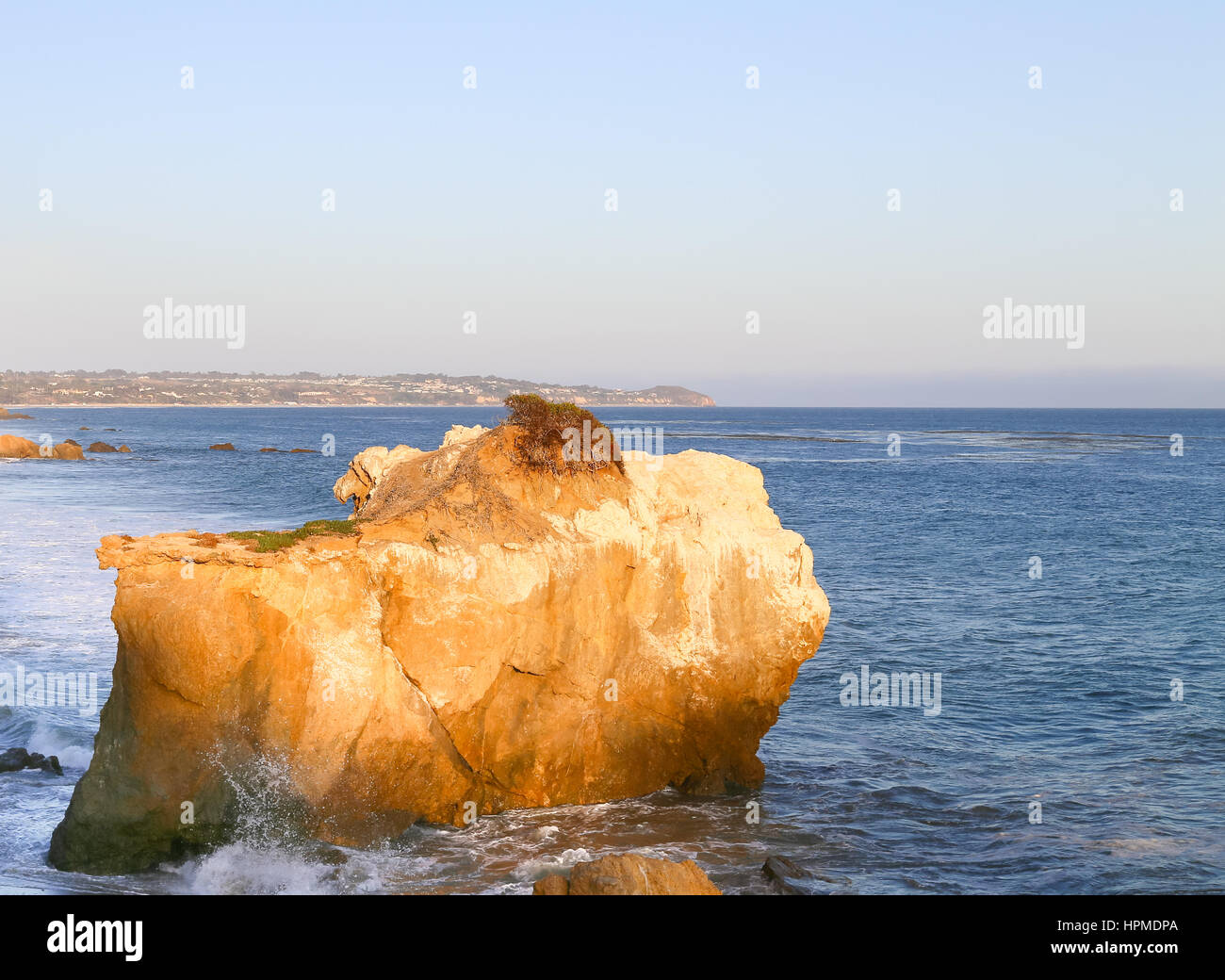 Sunlit rock hit by waves at El Matador State Beach in Malibu, USA Stock ...
