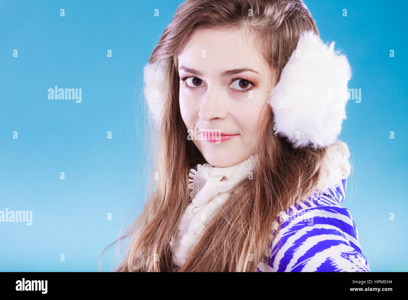 Teenage girl wearing fluffy white earmuff in winter fashion, cold time ...