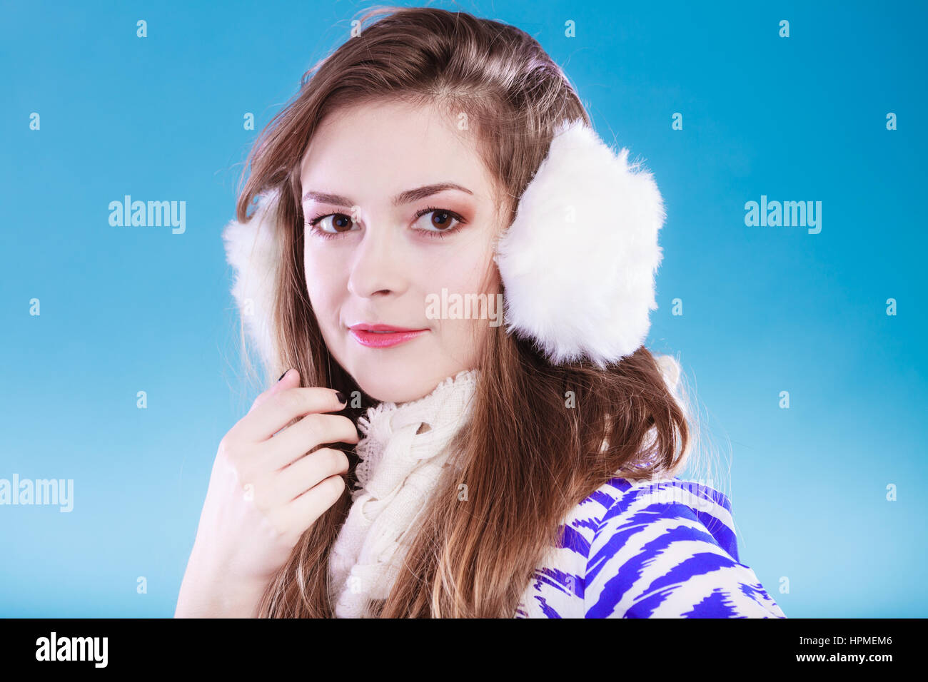 Teenage girl wearing fluffy white earmuff in winter fashion, cold time ...