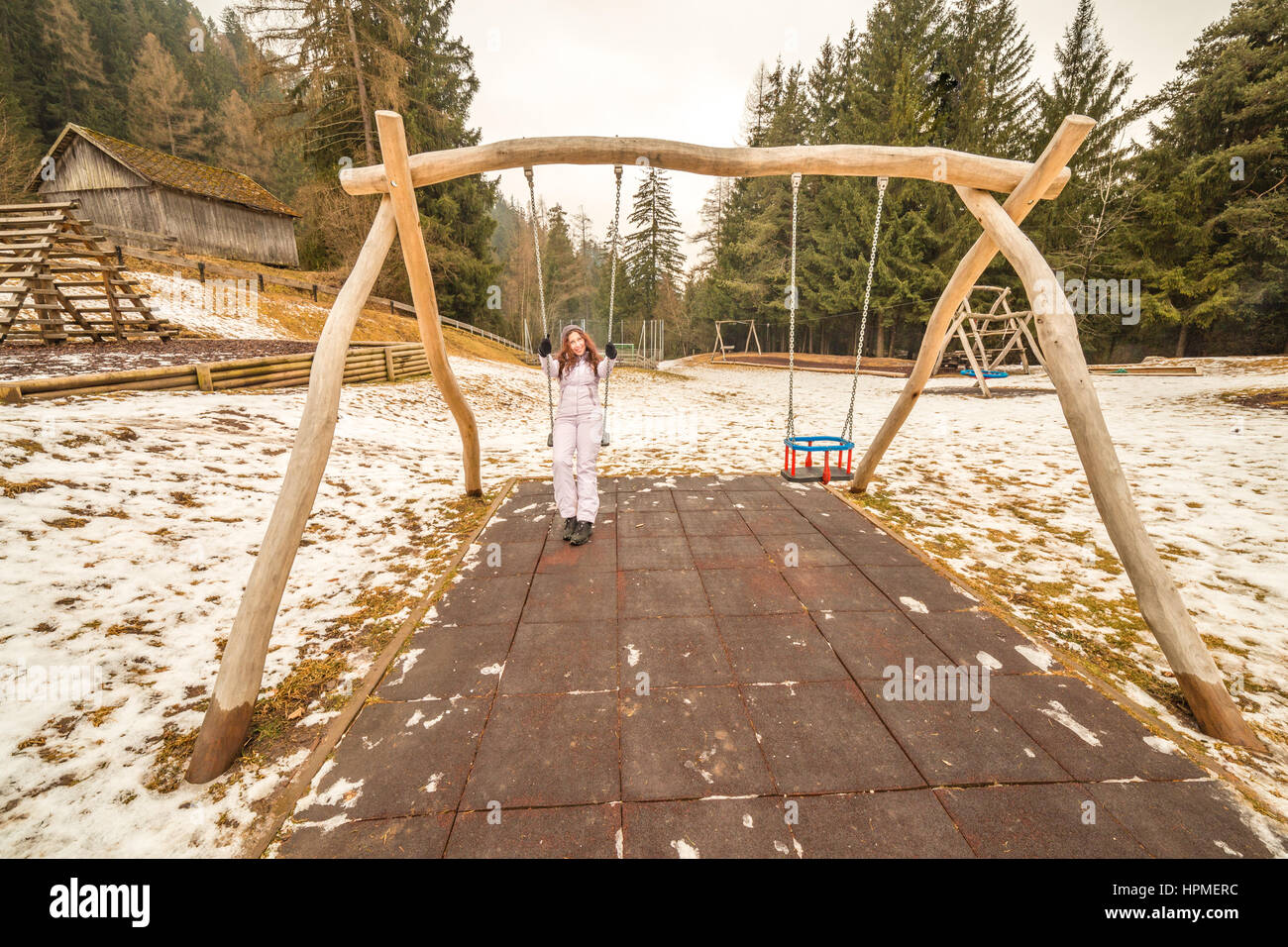 Happy woman rocking on the swing in a snowy park in mountains Stock ...