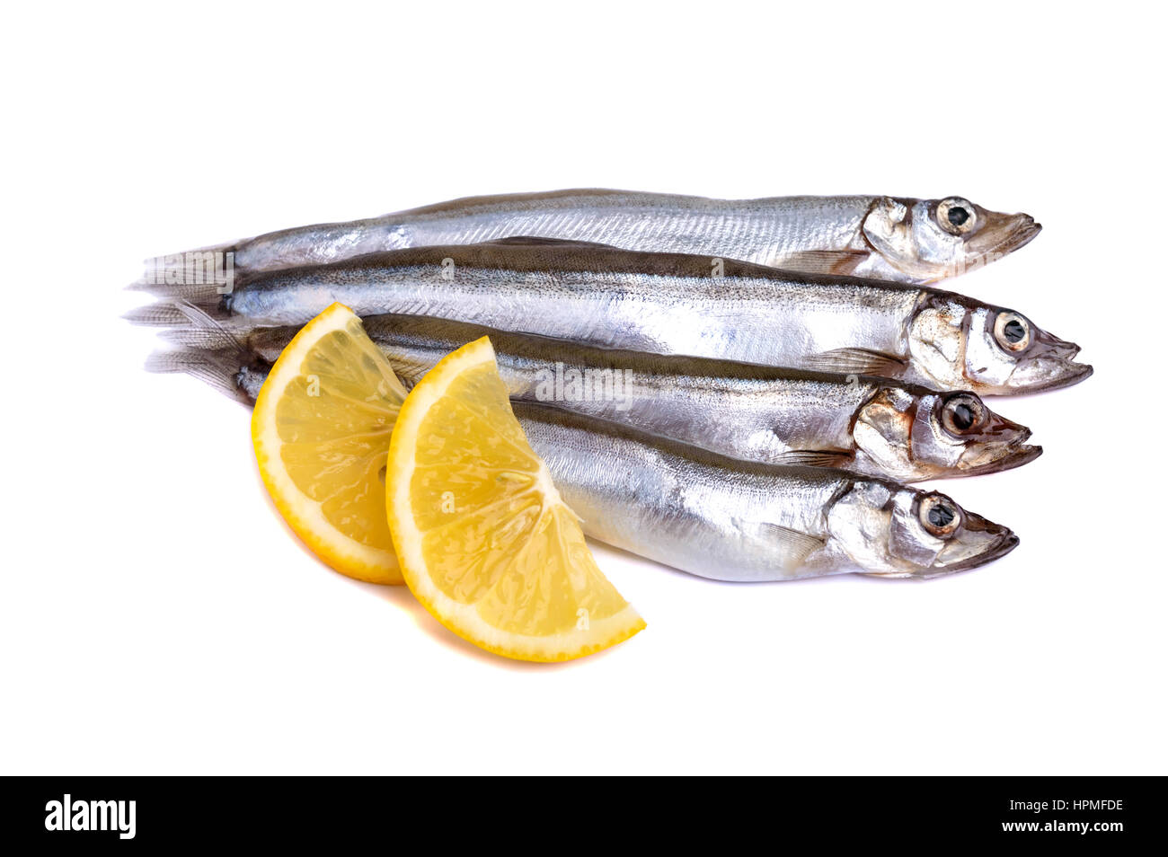 Raw fish capelin with lemon slices isolated on white background Stock ...
