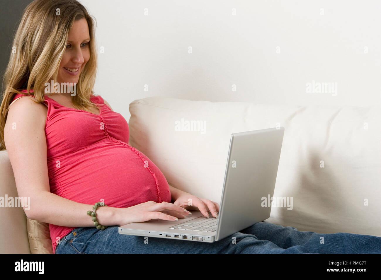 Pregnant woman typing on the computer Stock Photo - Alamy