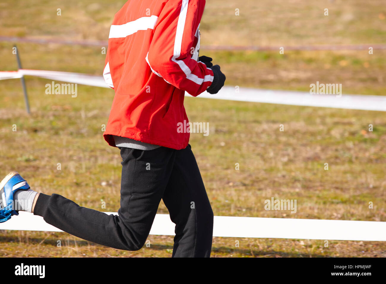 Young athletic runner with number on a race. Outdoor circuit ...