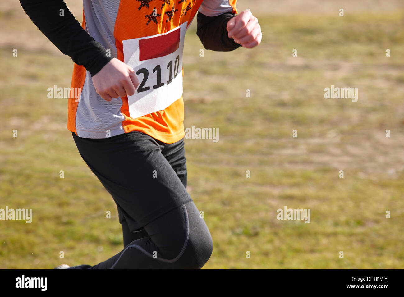 Young athletic runner on a cross country race. Outdoor circuit ...