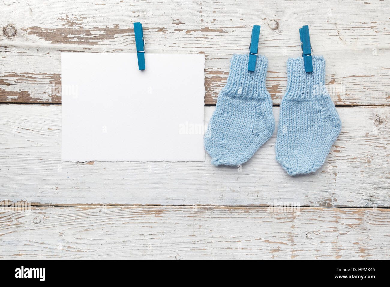 Baby socks hanging on white wooden background. Flat lay Stock Photo - Alamy