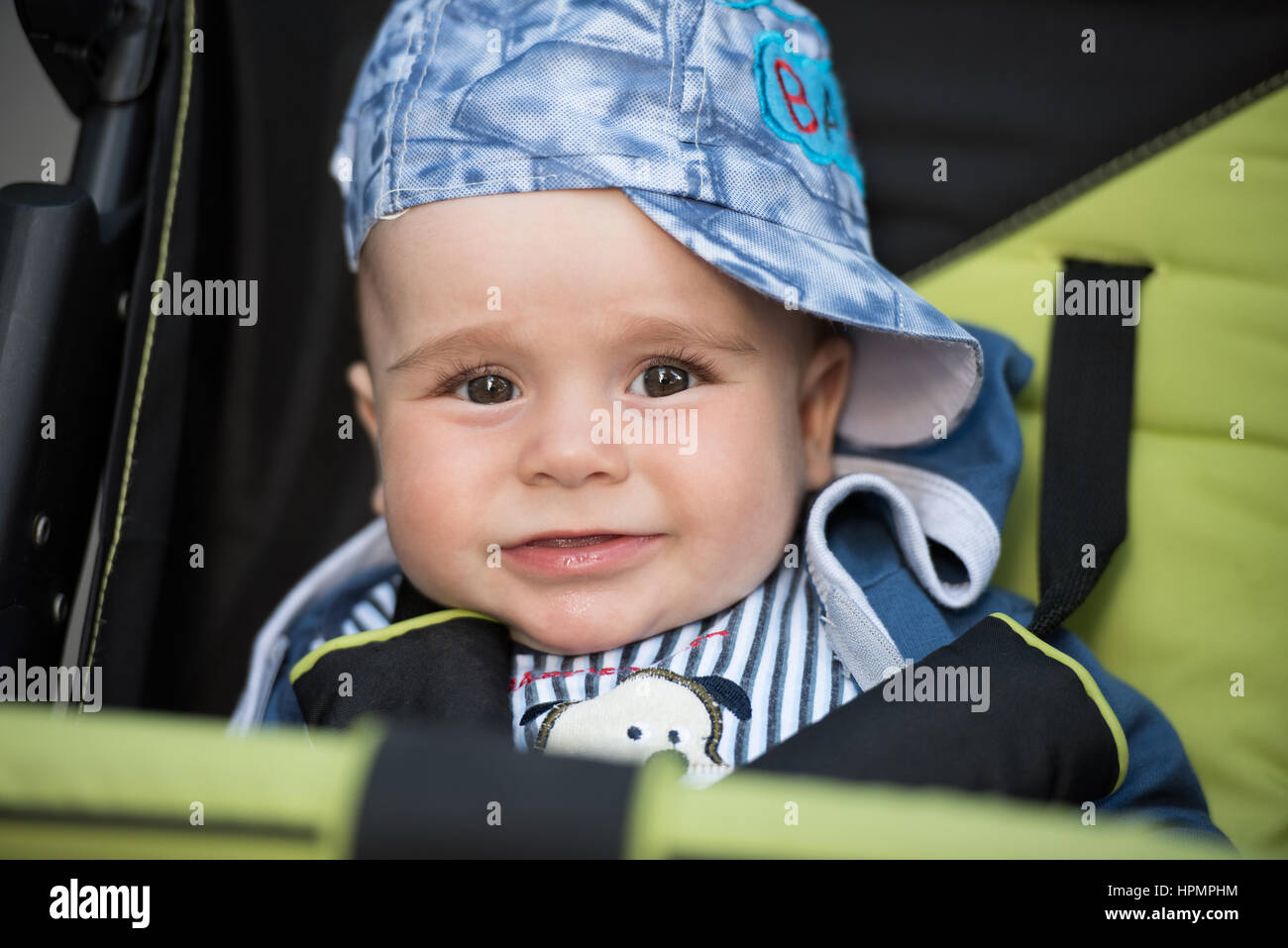 little and very beautiful baby boy sitting in the pram and waiting for ...