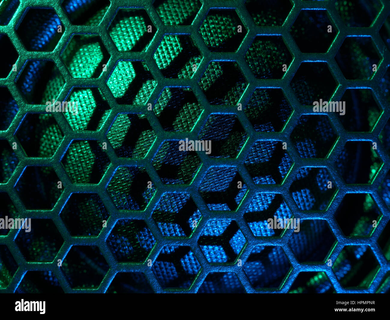 full frame colourful illuminated detail of a metallic grid in front of ...