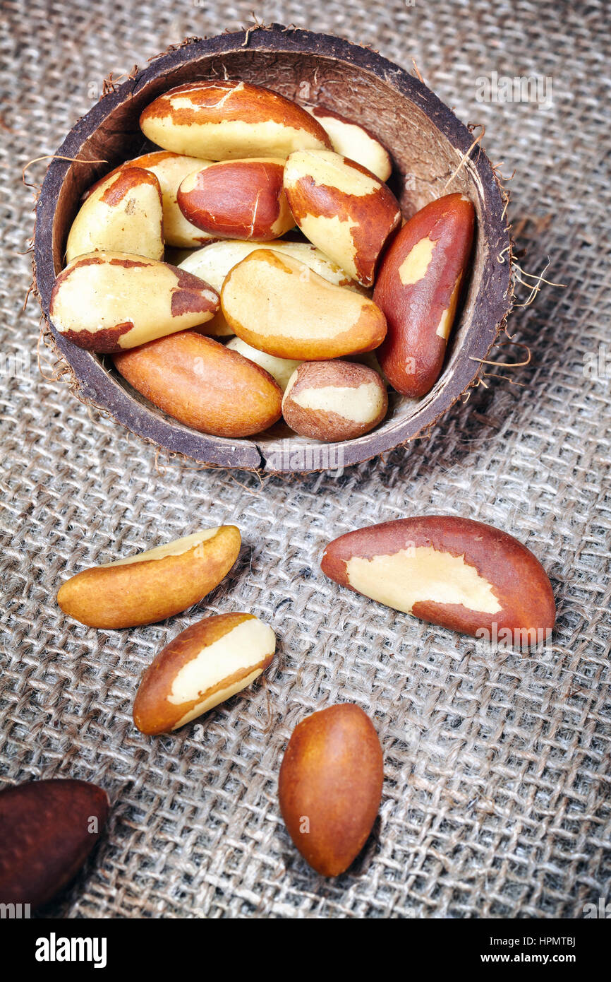 Brazil nuts in a coconut shell on linen background, selective focus ...