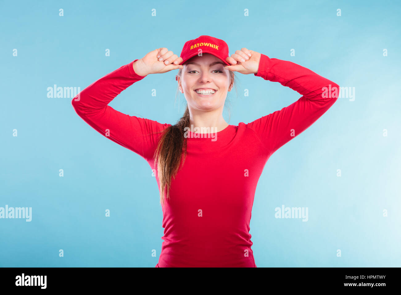 Portrait of happy lifeguard woman girl in red cap with ratownik sign on ...