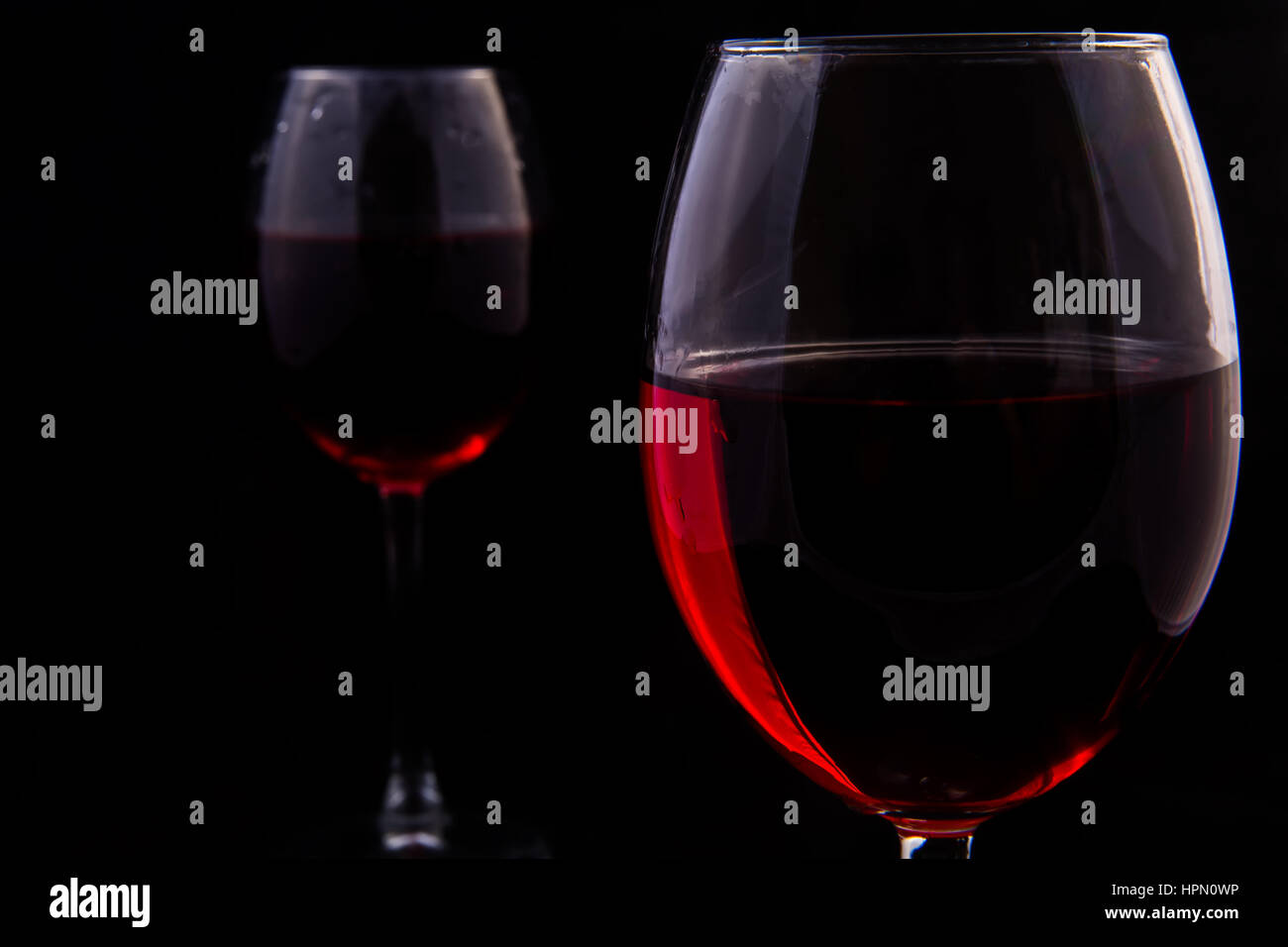 Two glasses of red vine on black background Stock Photo - Alamy