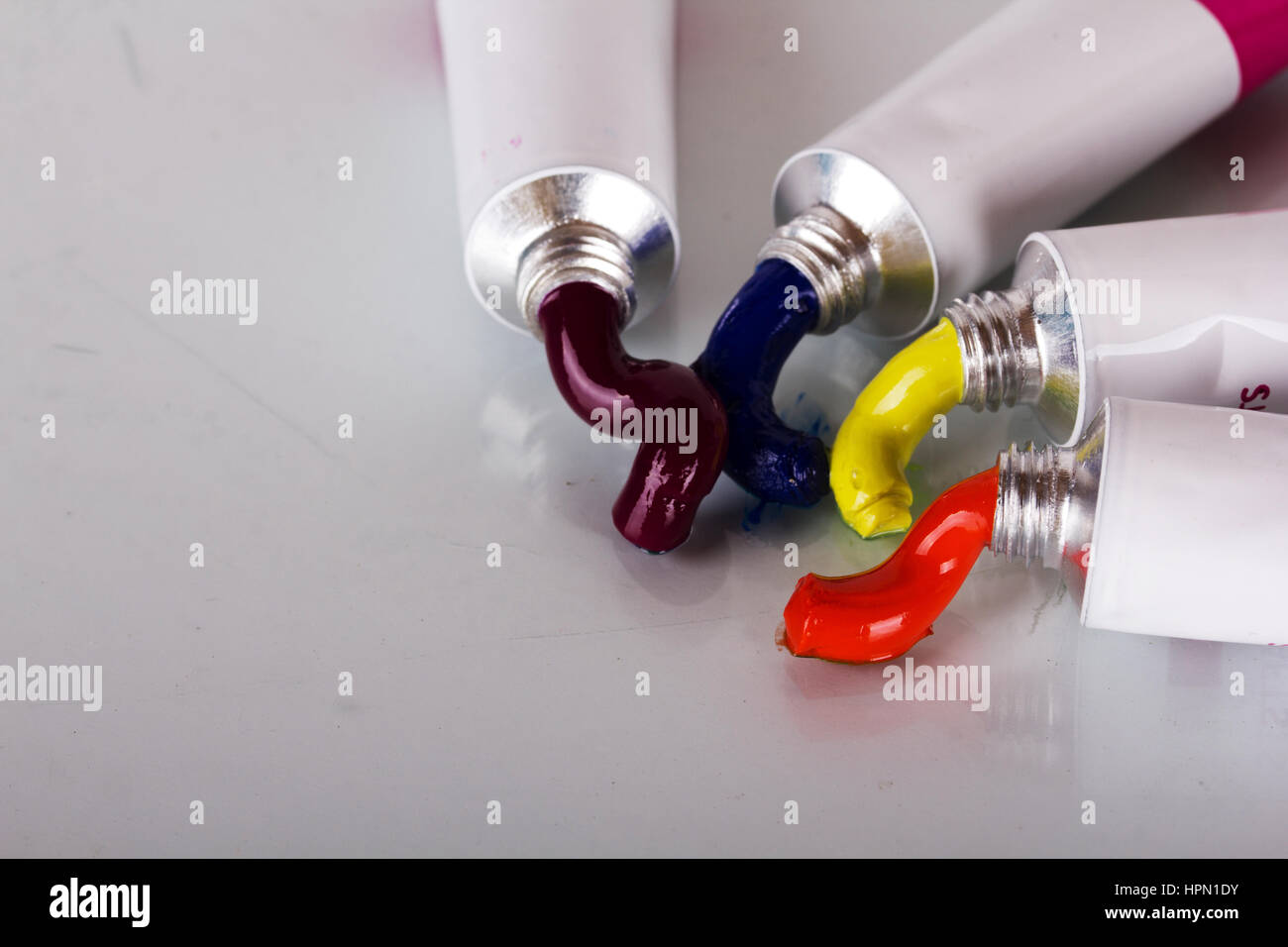 Open tubes with coloured paint squirting out Stock Photo - Alamy