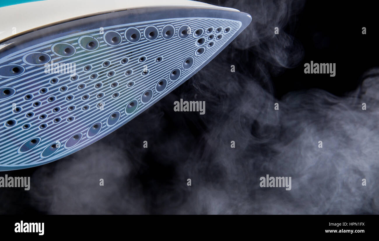 Close-up view of iron and steam on black background Stock Photo - Alamy