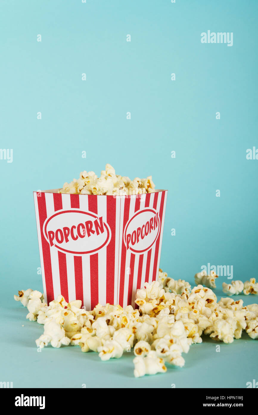 Bucket of popcorn against a blue background Stock Photo - Alamy