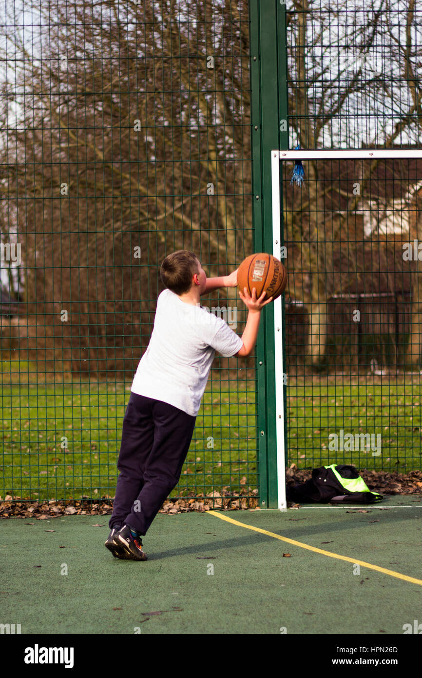 Child practicing playing basketball in a local park Stock Photo - Alamy