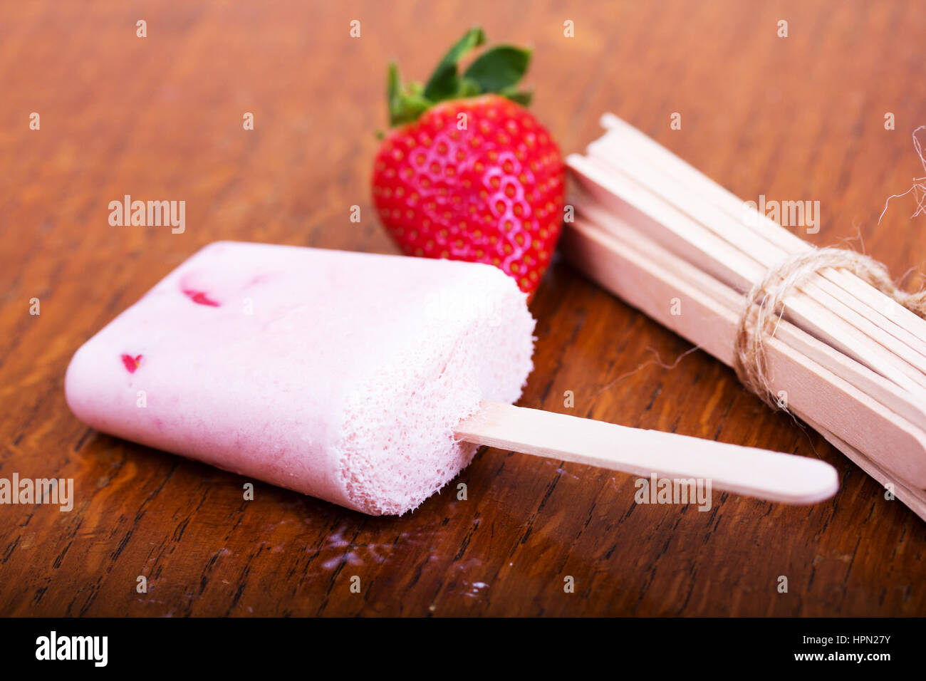 Homemade strawberry ice lolly on a rustic background Stock Photo - Alamy