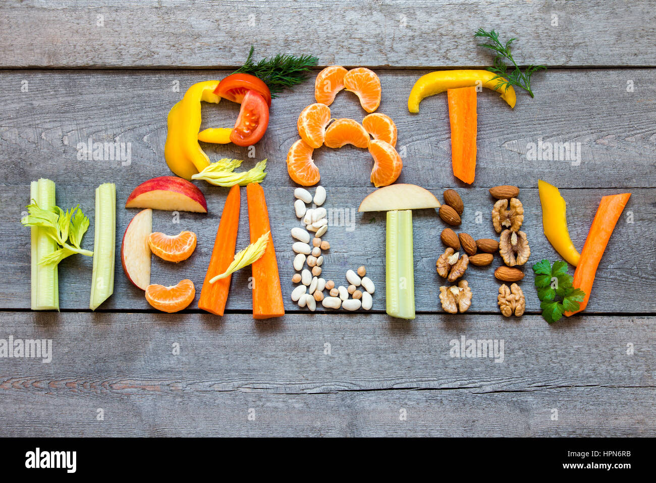 Words "Eat Healthy" written with vegetables, fruits, nuts and legumes ...