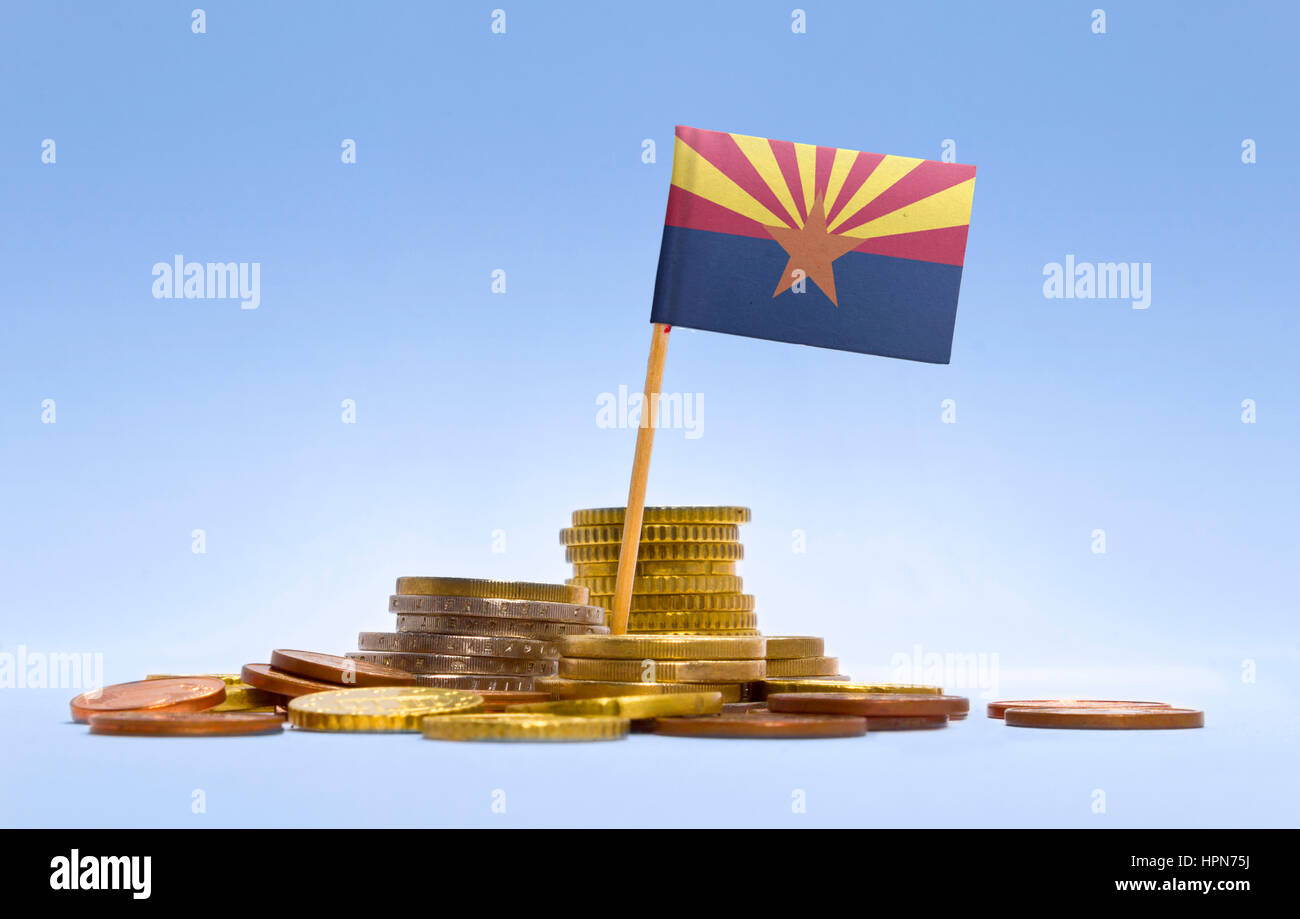 Flag of Arizona in a mixed stack of european coins and a blue ...