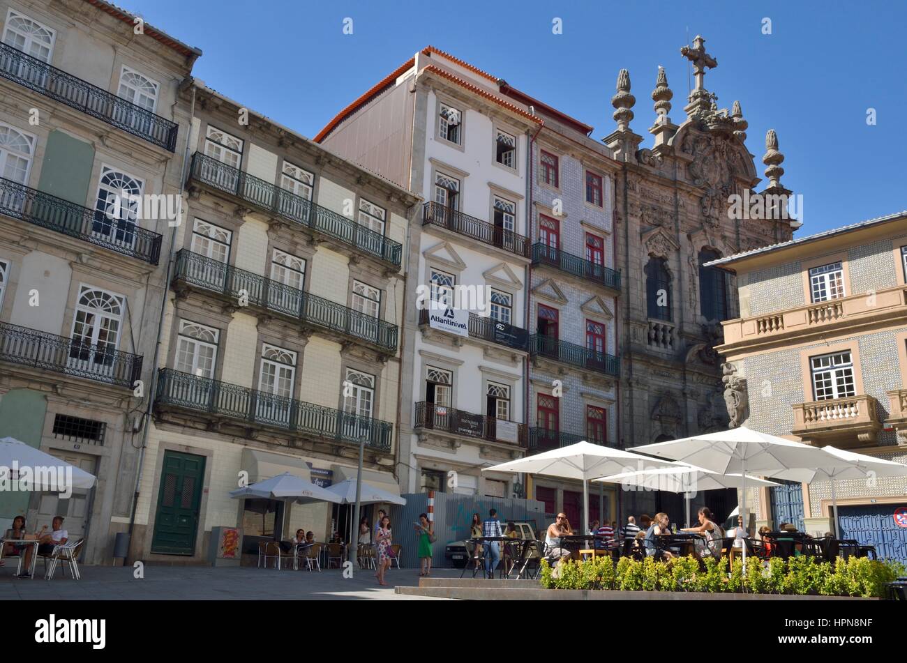 People at an outdoor restaurant in a plaza near the Ribeira in Porto ...