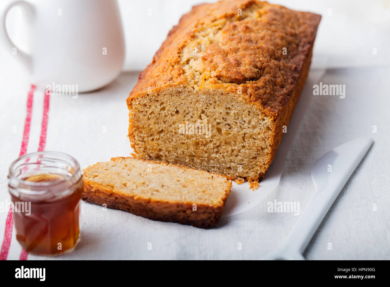 Cake, tea loaf with jam and cream on a textile white background. Rustic ...