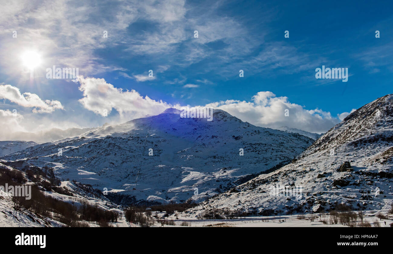 Panoramic view down snow covered valley in alpine mountain range with ...