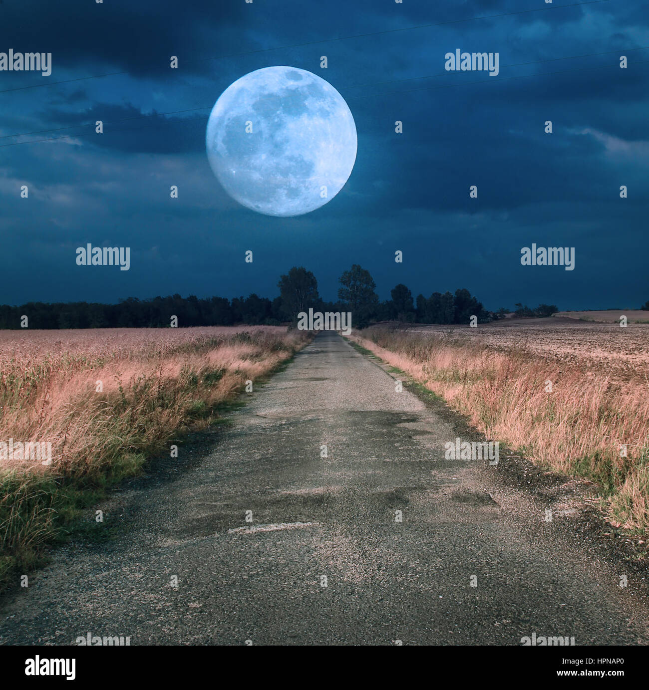 Moonrise over asphalt road Stock Photo - Alamy
