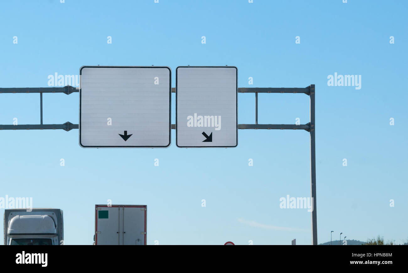 Two blank highway signs, each has arrow pointing direction where to go ...