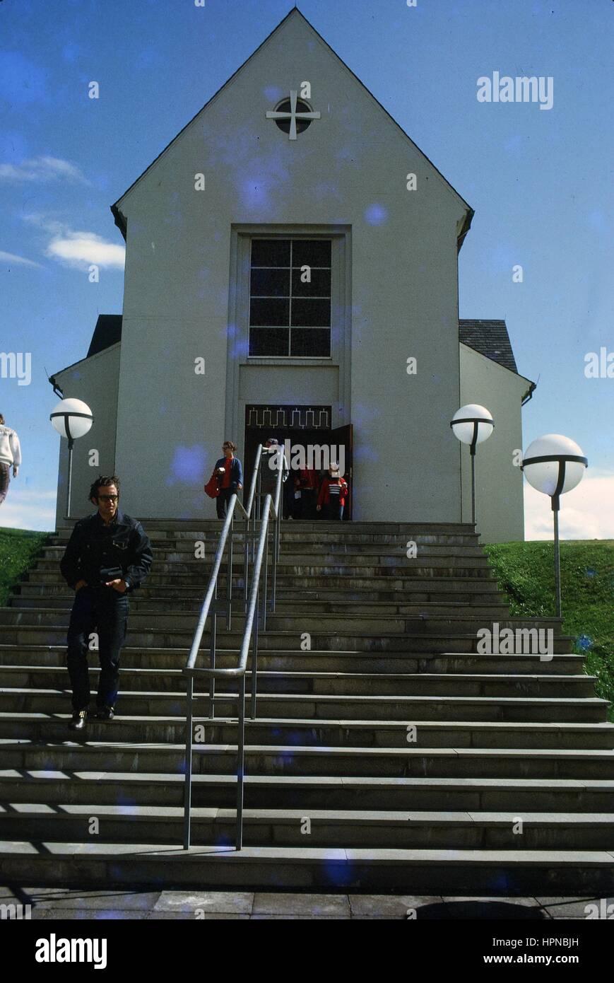 A male tourist walks down the steps of Skalholt church, Iceland, 1970 ...