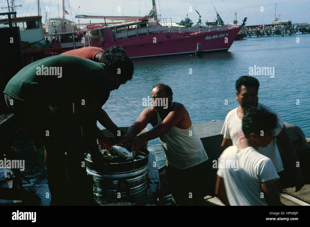 Native fishermen load their catch into a barrel, with the Ale Ale Kai ...