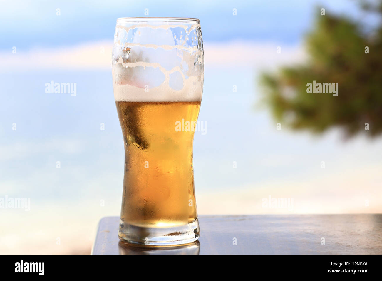 Close-up of light beer glass on sea background Stock Photo - Alamy