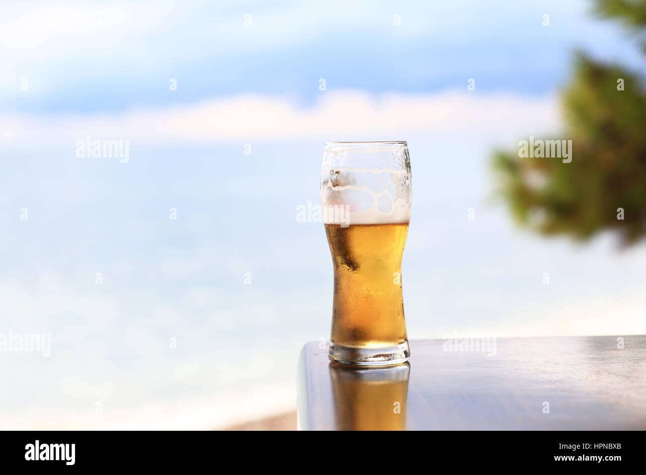 Glass of light beer on sea background Stock Photo - Alamy