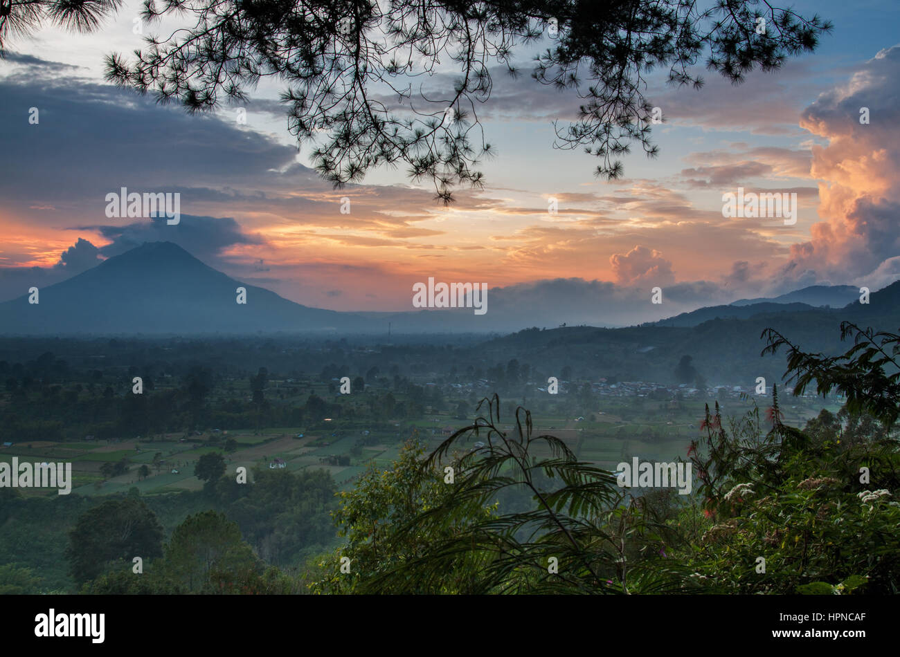 Distant View of Mount Sinabung Landscape seen at sunset with smoke ...