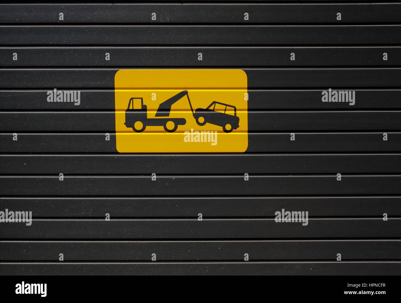 Metal garage door with a tow sign Stock Photo - Alamy