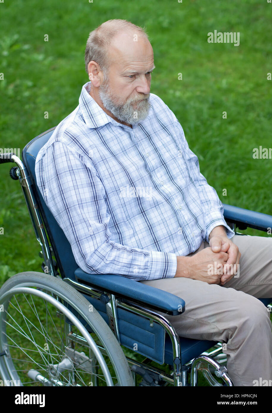 Handicapped elderly man sitting in a wheelchair Stock Photo - Alamy