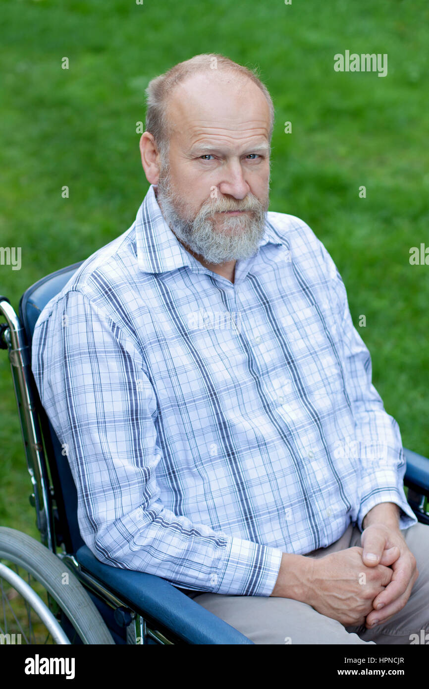 Handicapped elderly man sitting in a wheelchair Stock Photo - Alamy